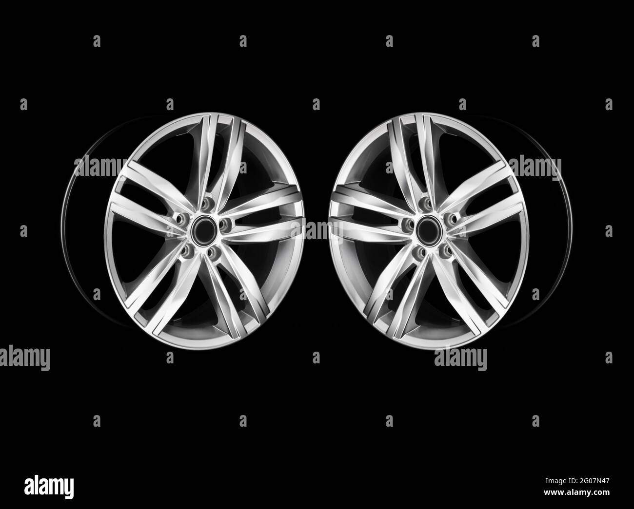 Pair of modern aluminium car wheels in dramatic light. Mirrored photo ...