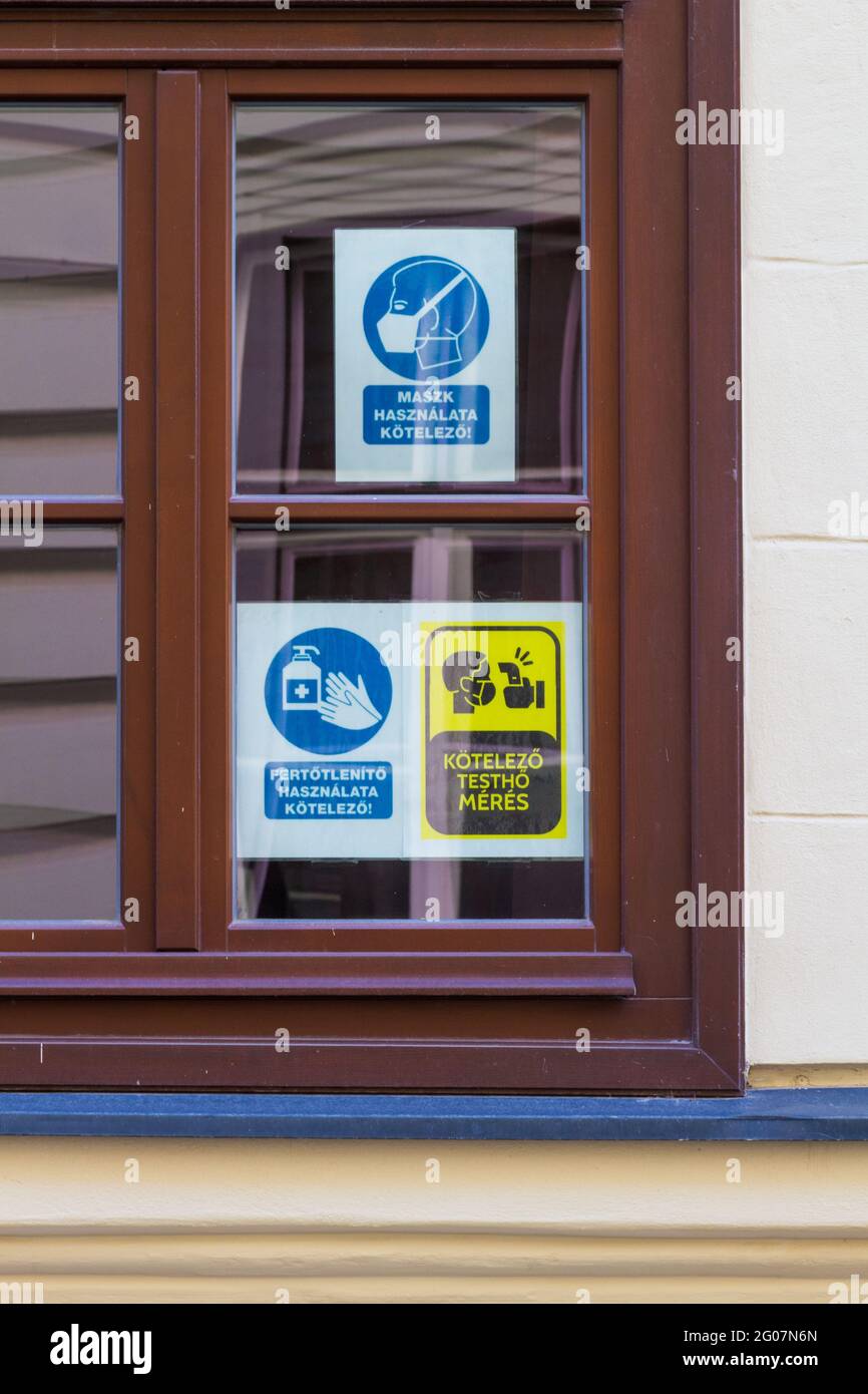 Restriction sign stuck on window of school. Using face mask, sanitiser ...
