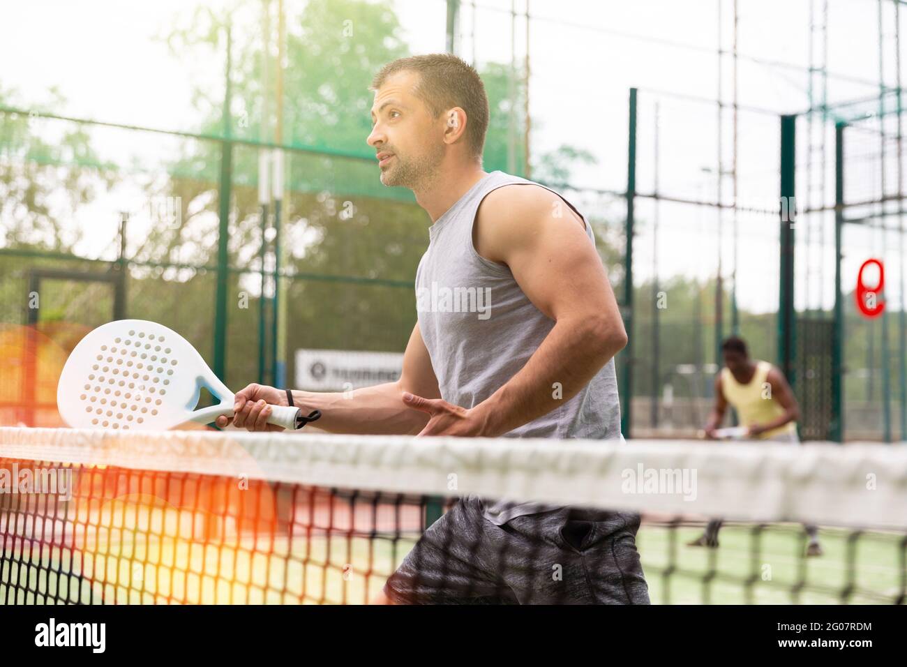 Male players playing padel in a padel court outdoor behind net Stock ...