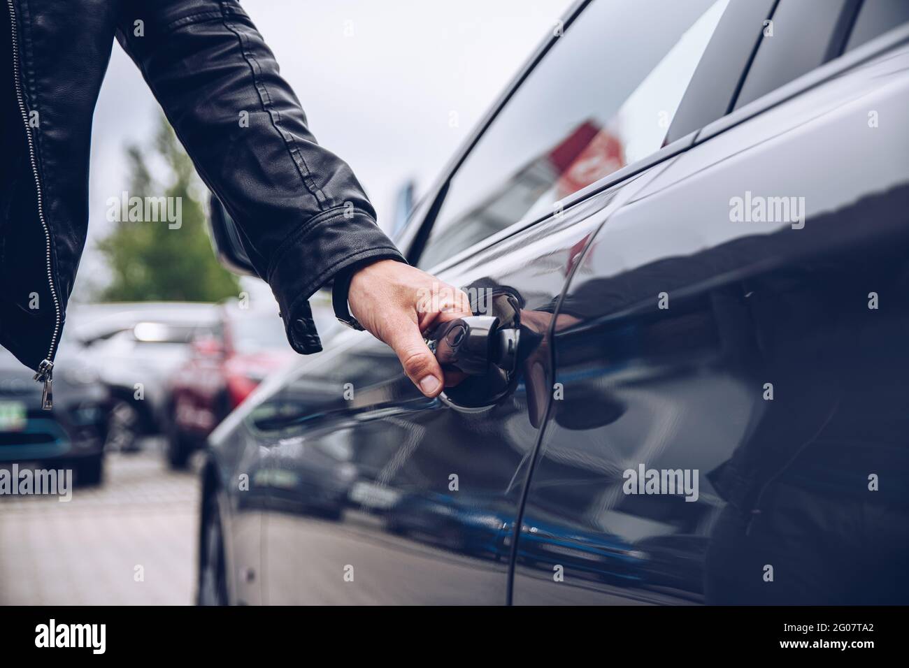 Man is reaching for the car door handle Stock Photo - Alamy