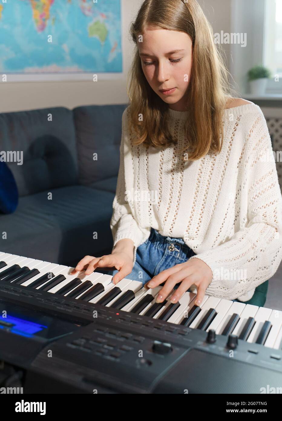 Teenage girl playing electronic musical instrument at home Stock Photo ...