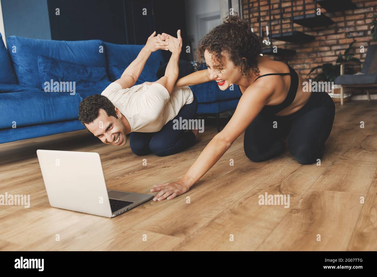 Fit young man doing sport exercise at home with laptop lying on floor ...