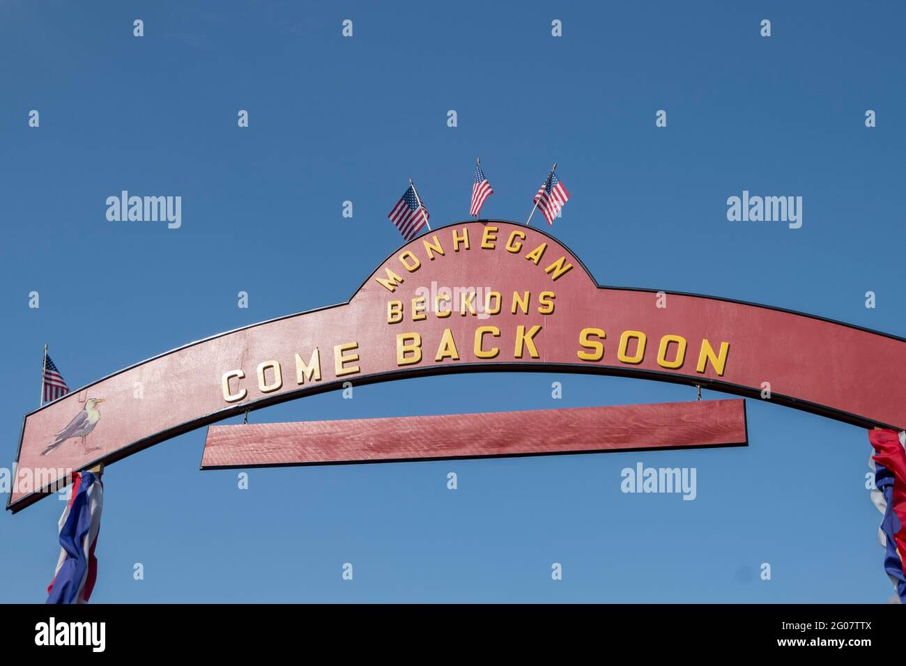 The back side of the main red, wood, arched, gateway Welcome sign. On ...