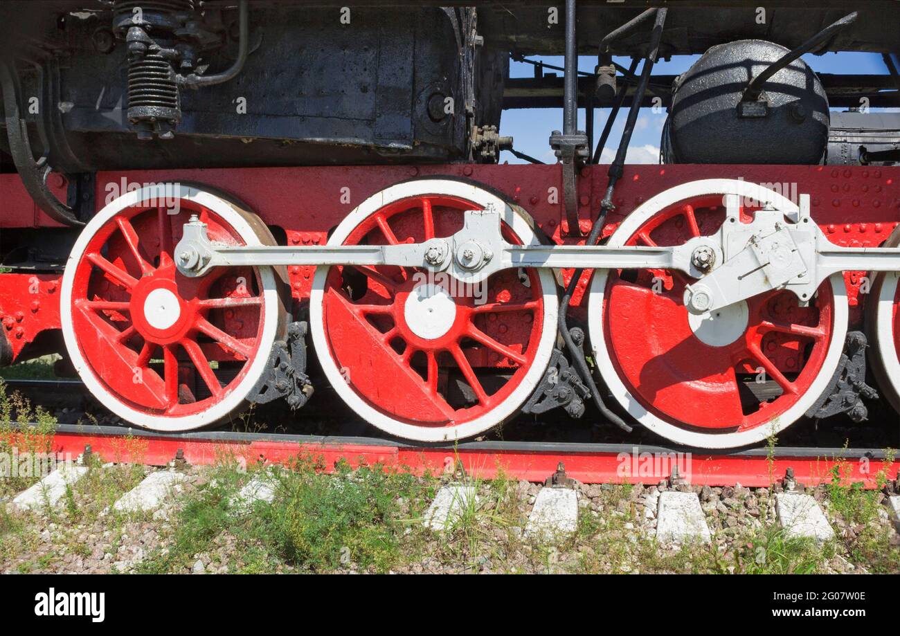 Three wheels and coupling devices of a big old steam locomotive close ...