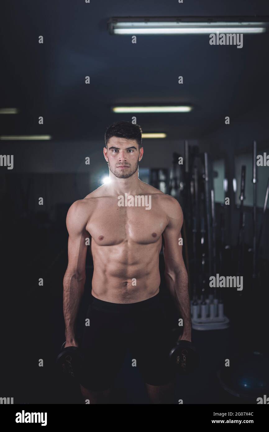 Fitness man working his muscles in the gym, it is his healthy and ...