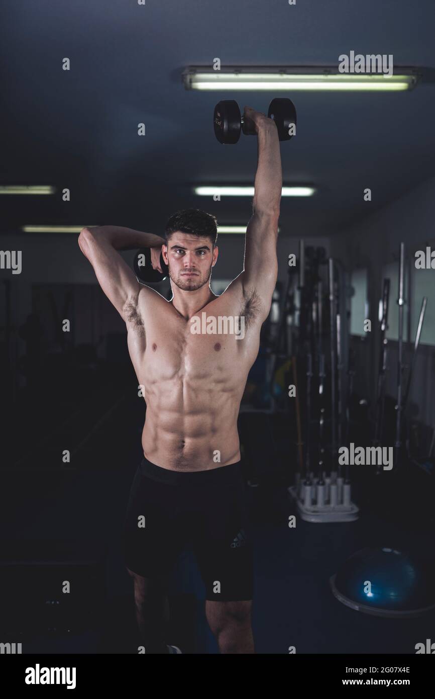 Fitness man working his muscles in the gym, it is his healthy and ...