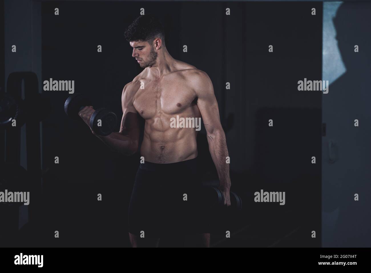 Fitness man working his muscles in the gym, it is his healthy and ...