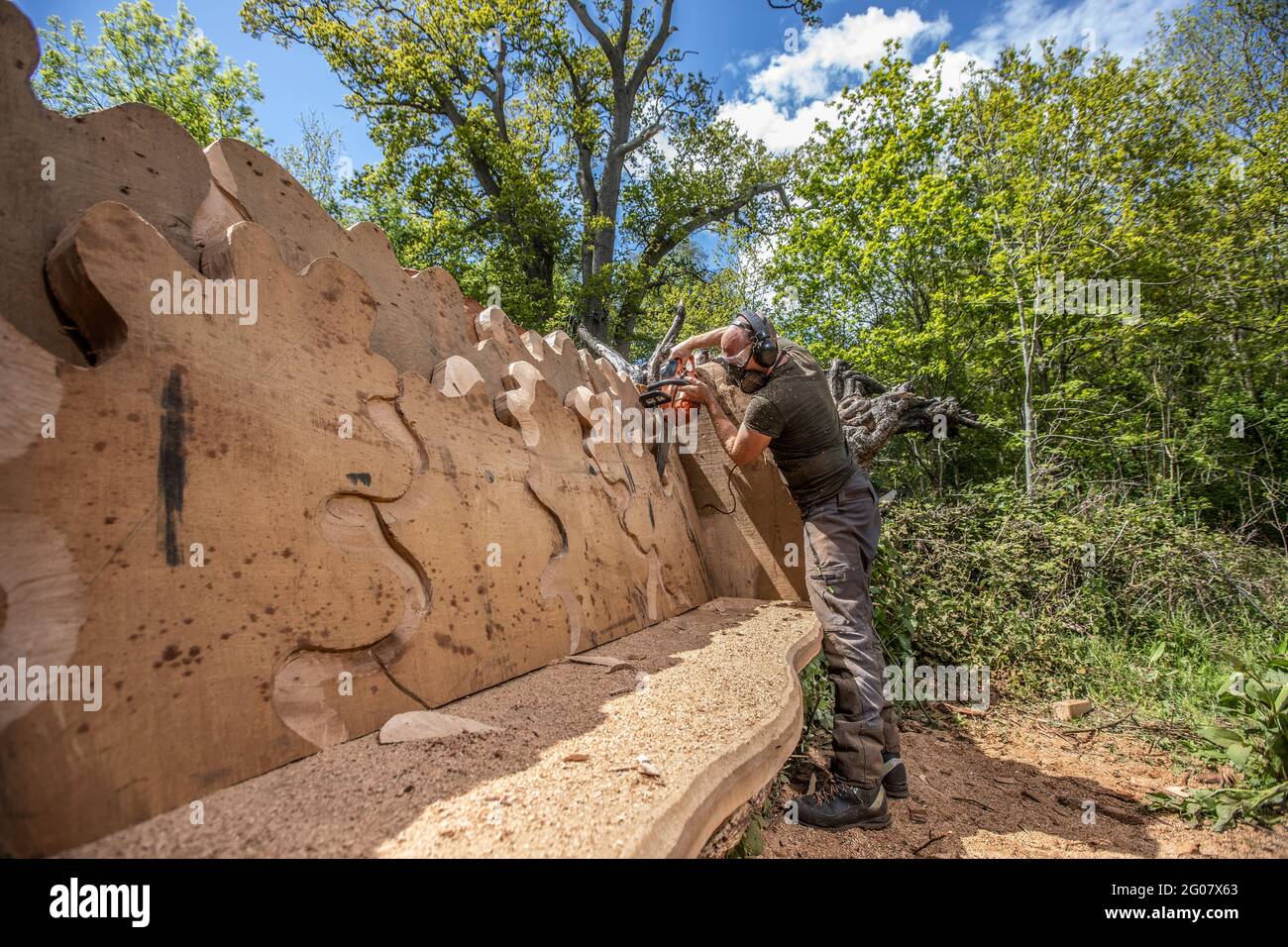 Matt Crabb, national chainsaw carving champion sculpting a bench out of ...