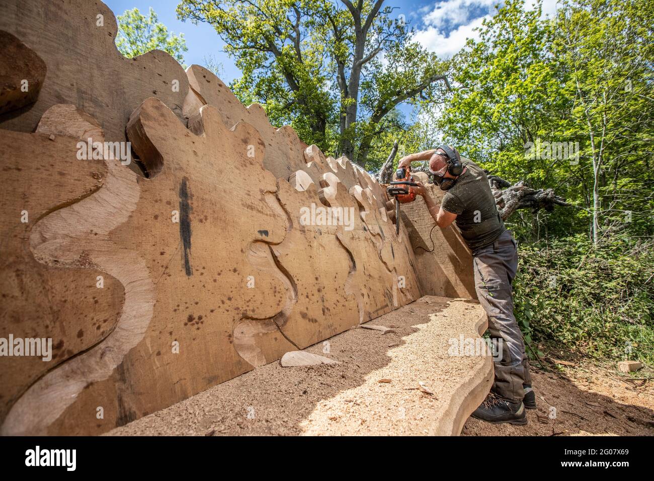 Matt Crabb, national chainsaw carving champion sculpting a bench out of ...
