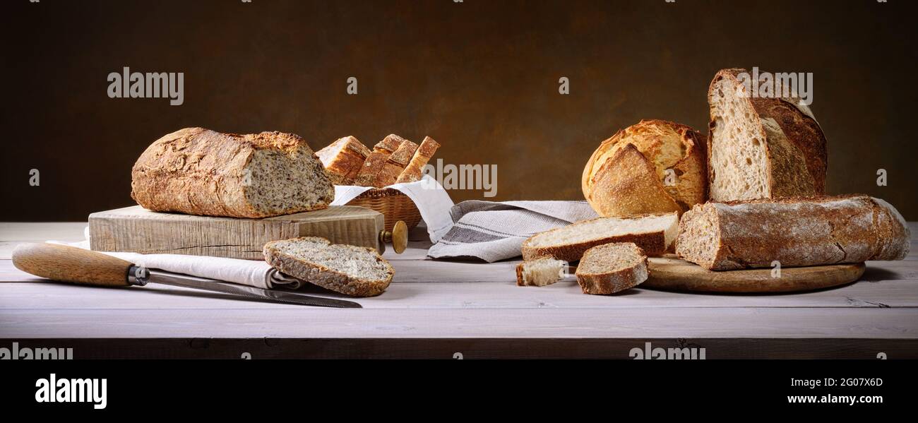 Various sizes of traditional bread with cutting boards and knife on ...