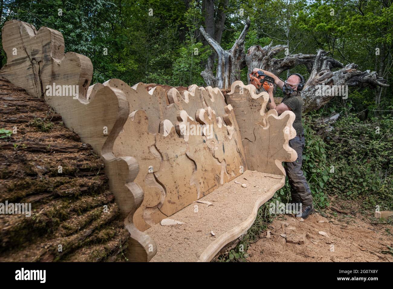 Matt Crabb, national chainsaw carving champion sculpting a bench out of ...