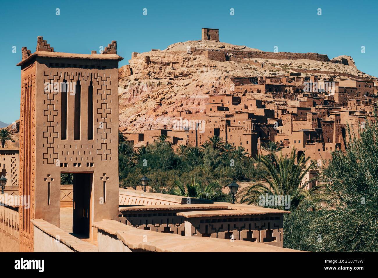 Ancient buildings of brown stone among green tropical plants and desert ...