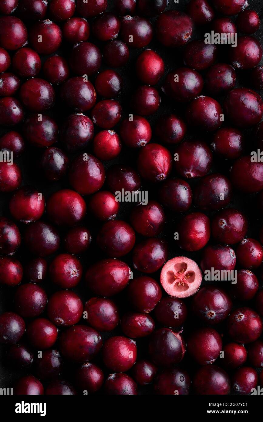 Top view of fresh red blueberries and in detail one of them cut in half ...
