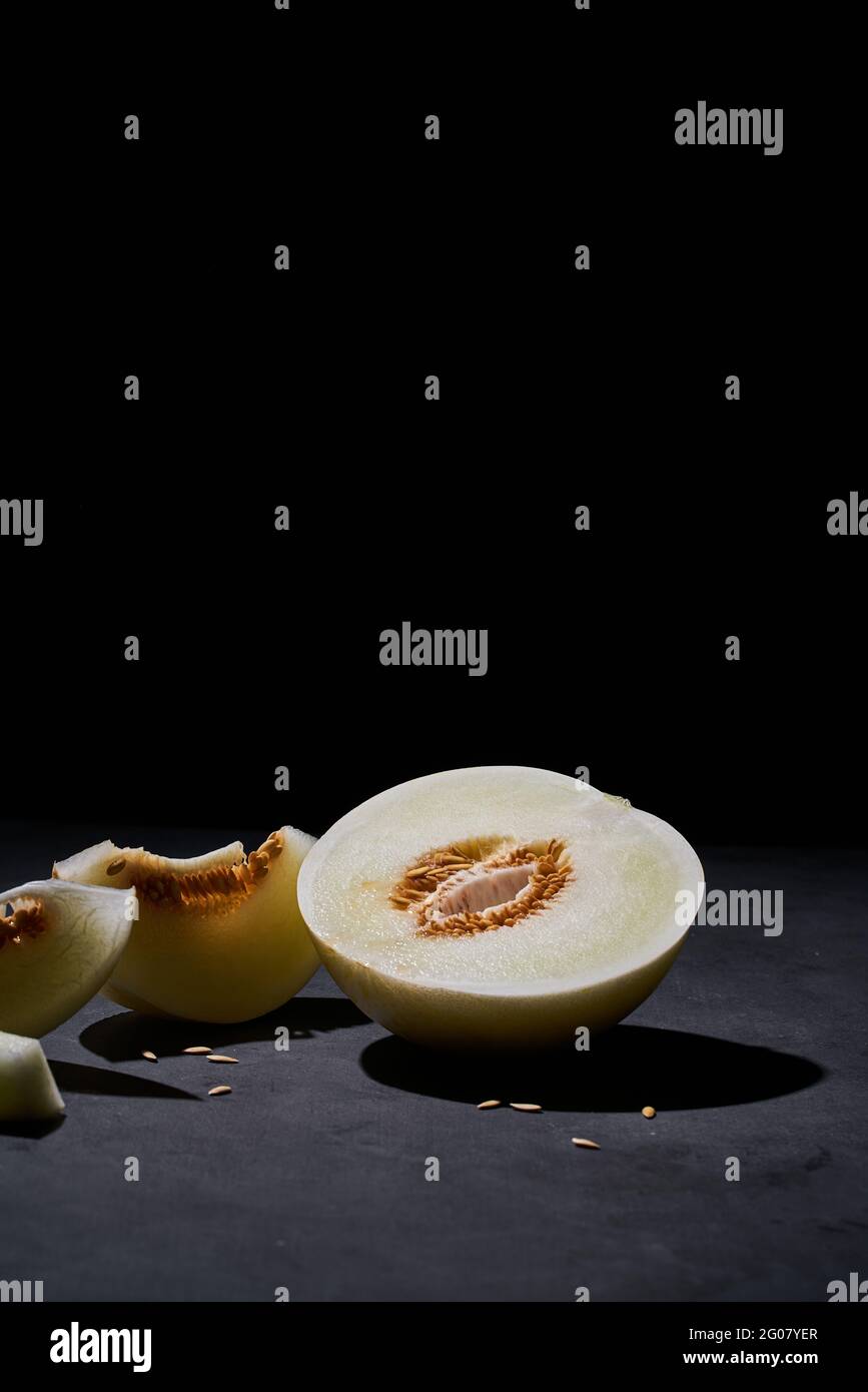 Side view of a fresh melon cut in half on black background Stock Photo ...