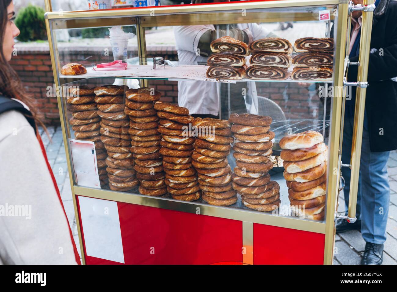 Crop female standing selecting fresh buns from display case near crop ...