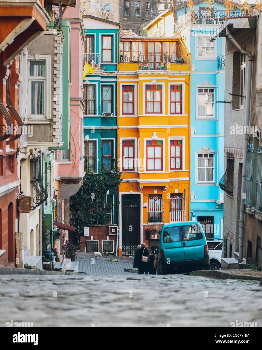 Paved road near colorful houses and blue car on city street in Turkey ...
