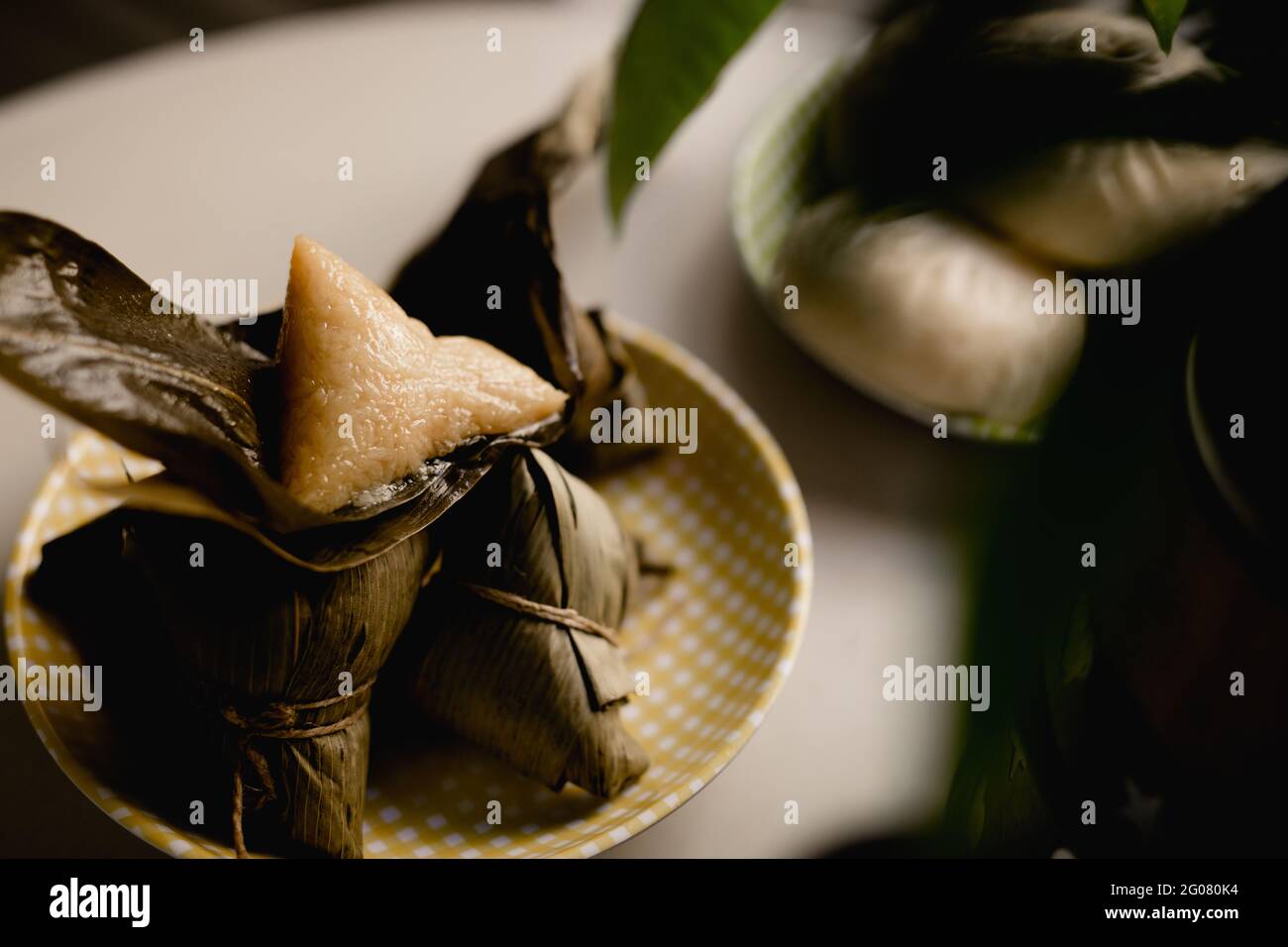 Opened and covered bamboo leaf rice dumplings placed on cute checked ...