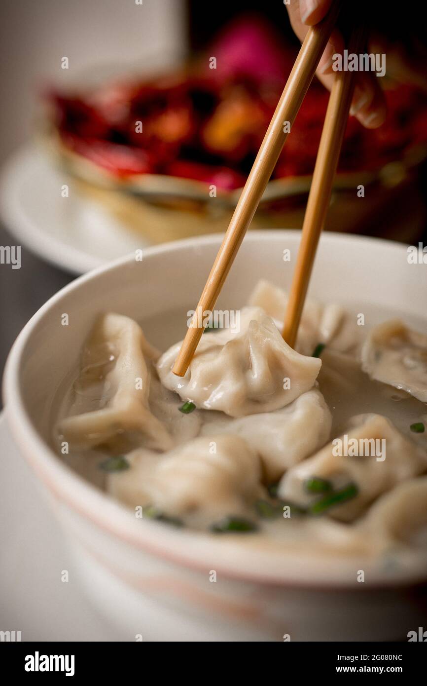 Hand with chopsticks holding chinese dumpling hi-res stock photography ...