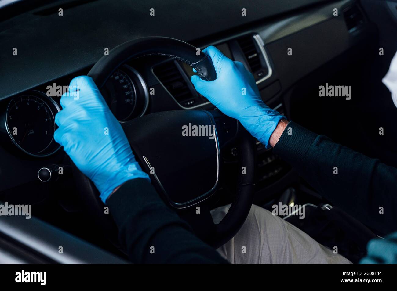 Side view of cropped unrecognizable man using a protective mask driving ...