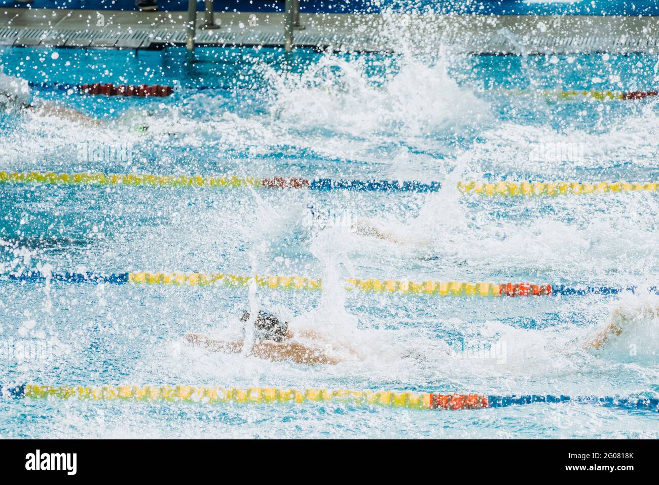 From above side view of people diving in water with splashes in pool ...