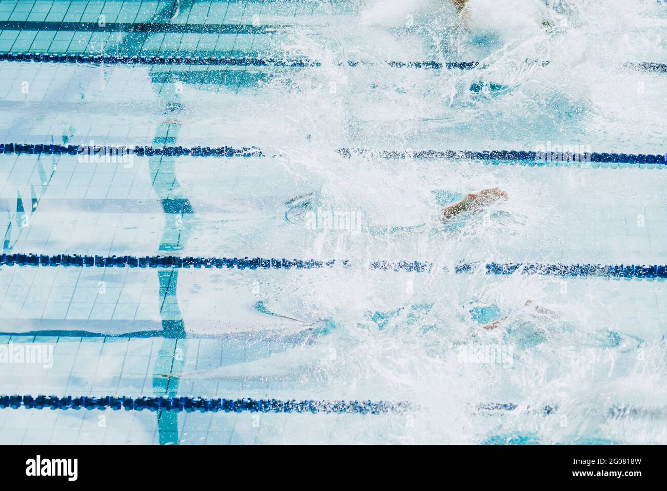 From above side view of people diving in water with splashes in pool ...