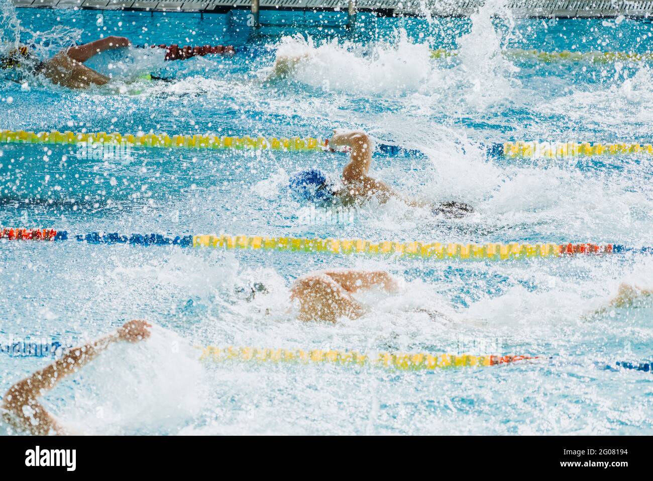 From above side view of people diving in water with splashes in pool ...