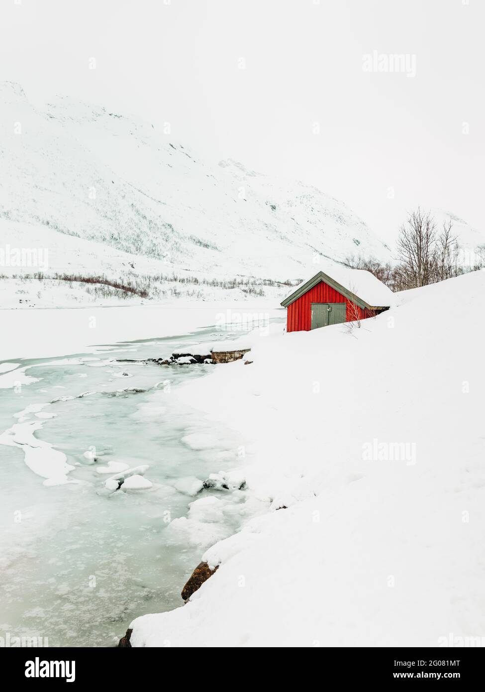 Red shack located on white snowy riverside on Lofoten Islands, Norway ...