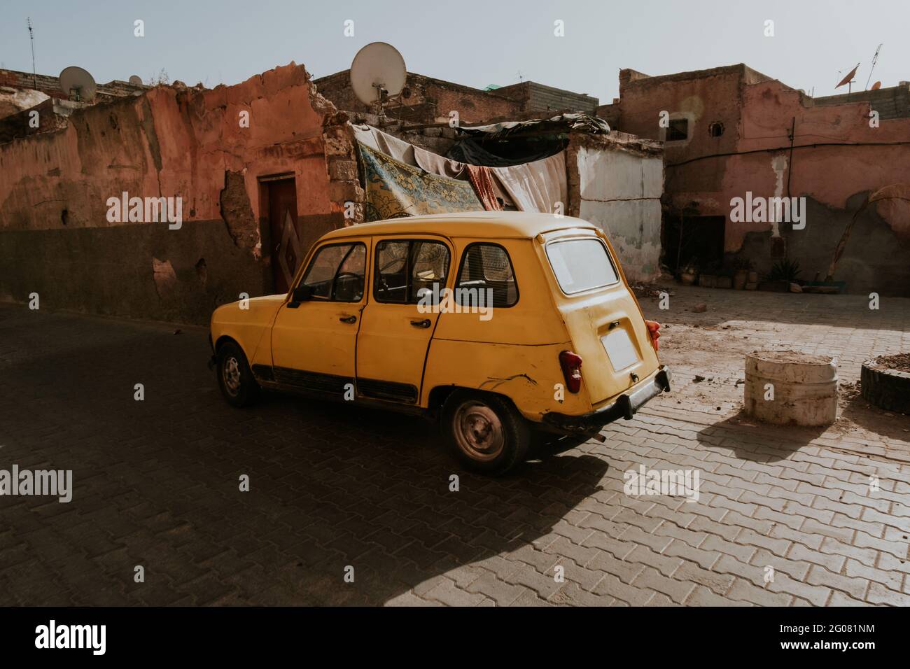 Vintage car parked near destroyed houses on street of ghetto in ...