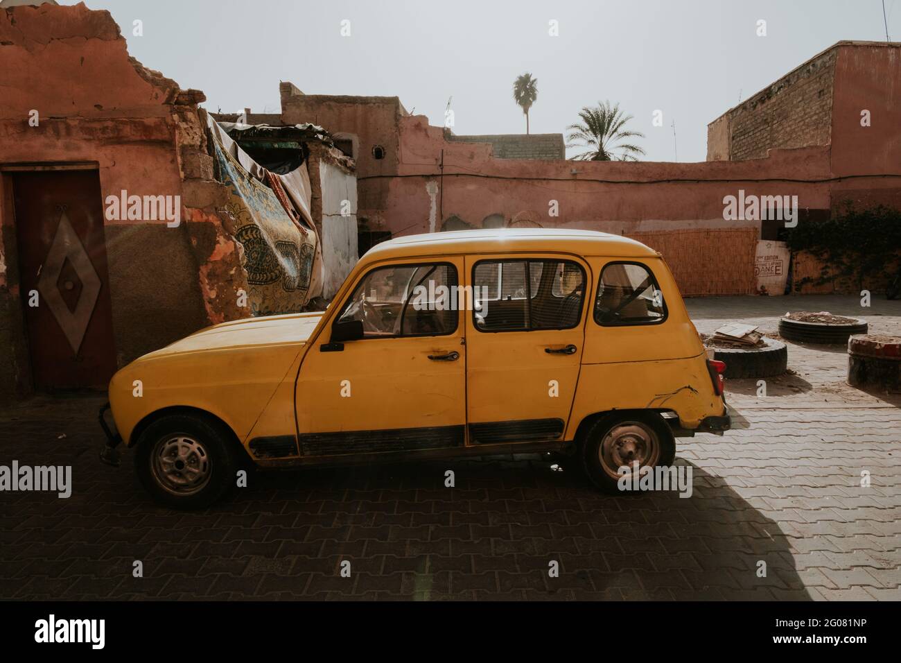 Vintage car parked near destroyed houses on street of ghetto in ...