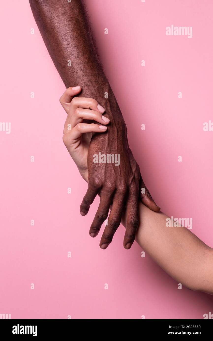 Multi-ethnic hands of white Woman and black man touching each other ...