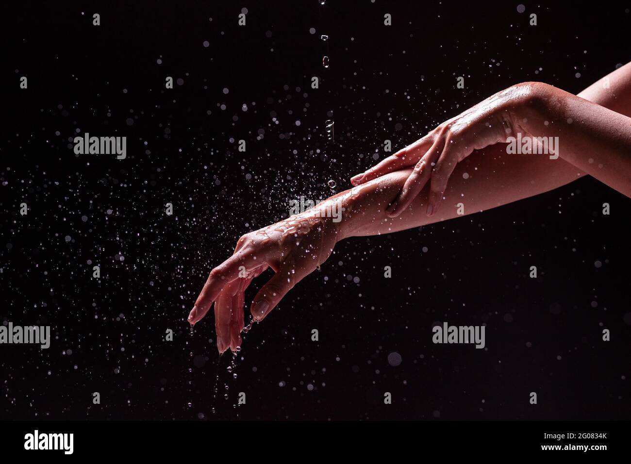 Crop view of anonymous Woman washing hands and forearm with splashing ...