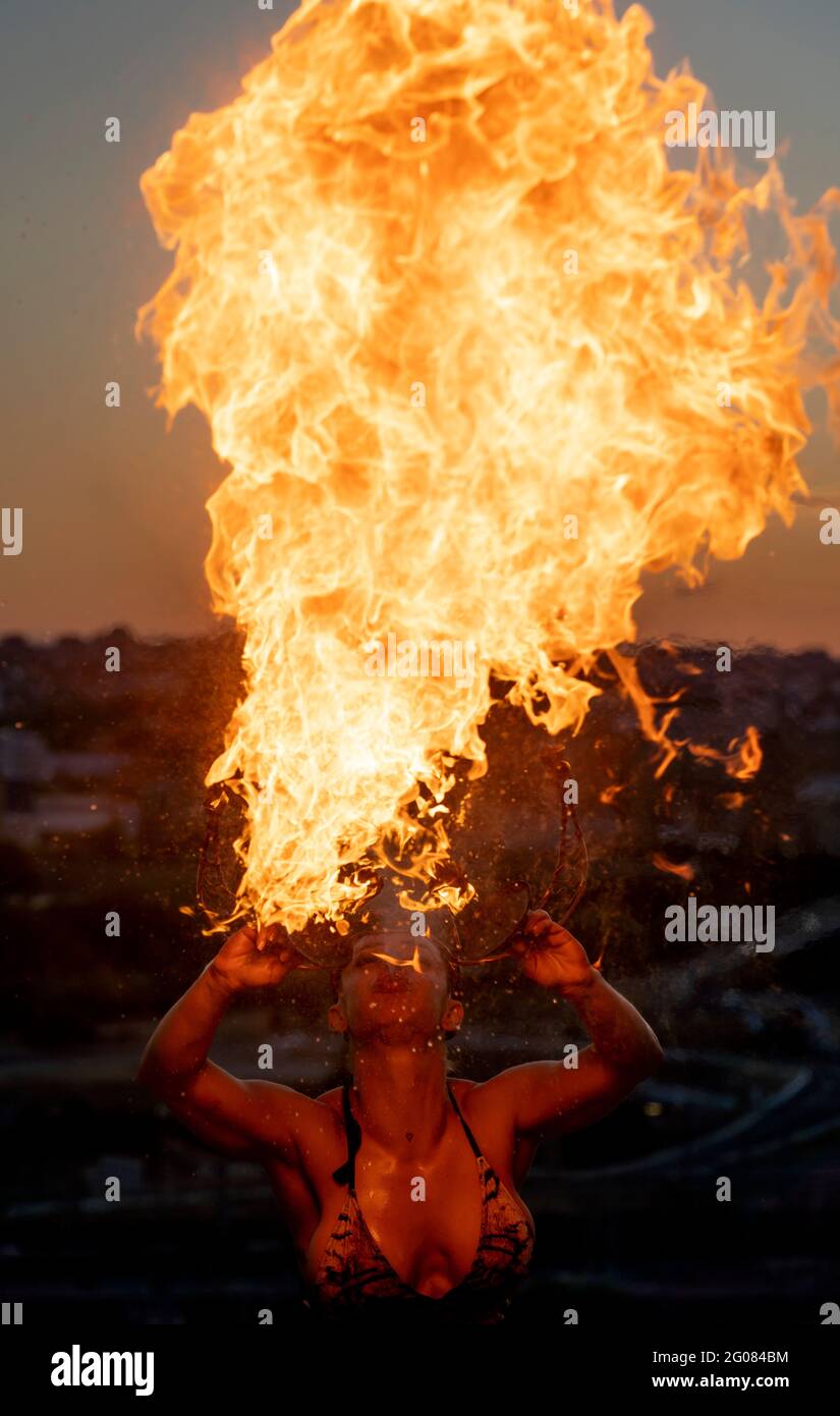 Fire-Eater Woman Performing Spit Fire At Sunset Stock Photo - Alamy