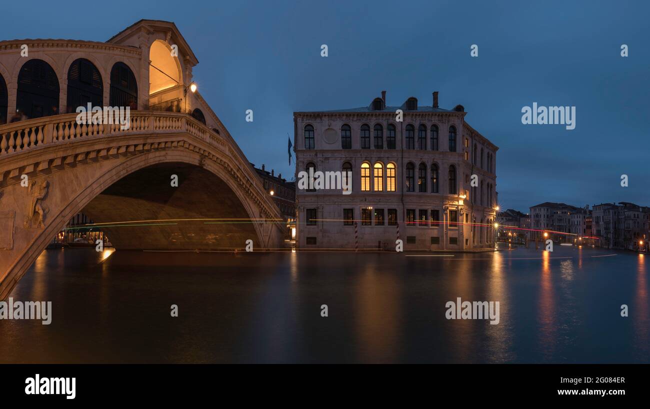 Beautiful ancient bridge and house near calm water of channel against ...