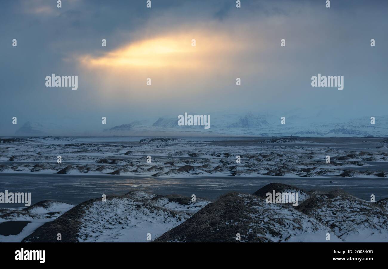 Frosted area covered with snow and dramatic overcast with peeking ...