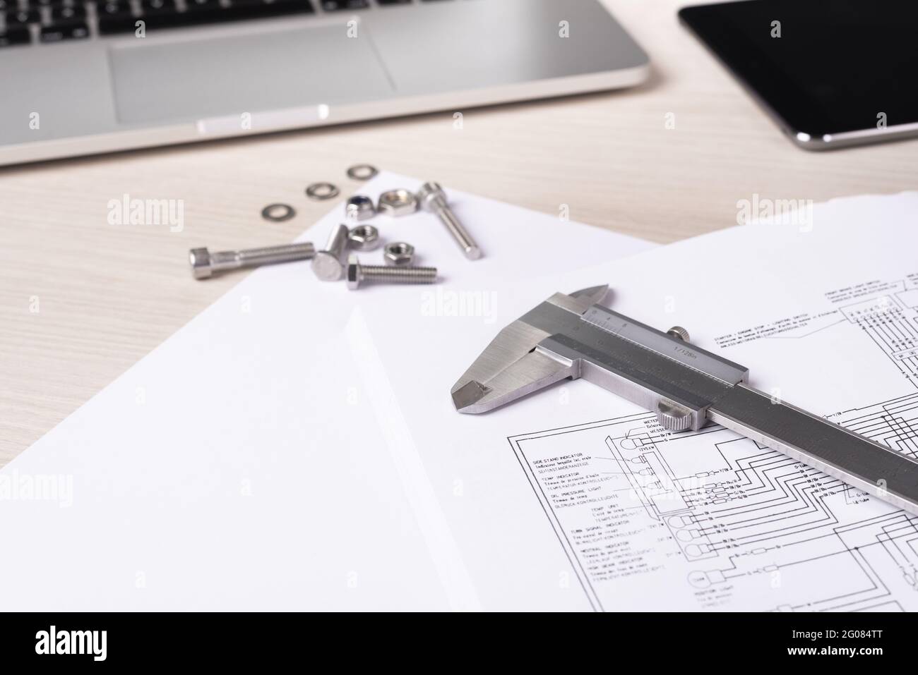 Closeup shot of the papers, vernier caliper, tablet with architectural ...