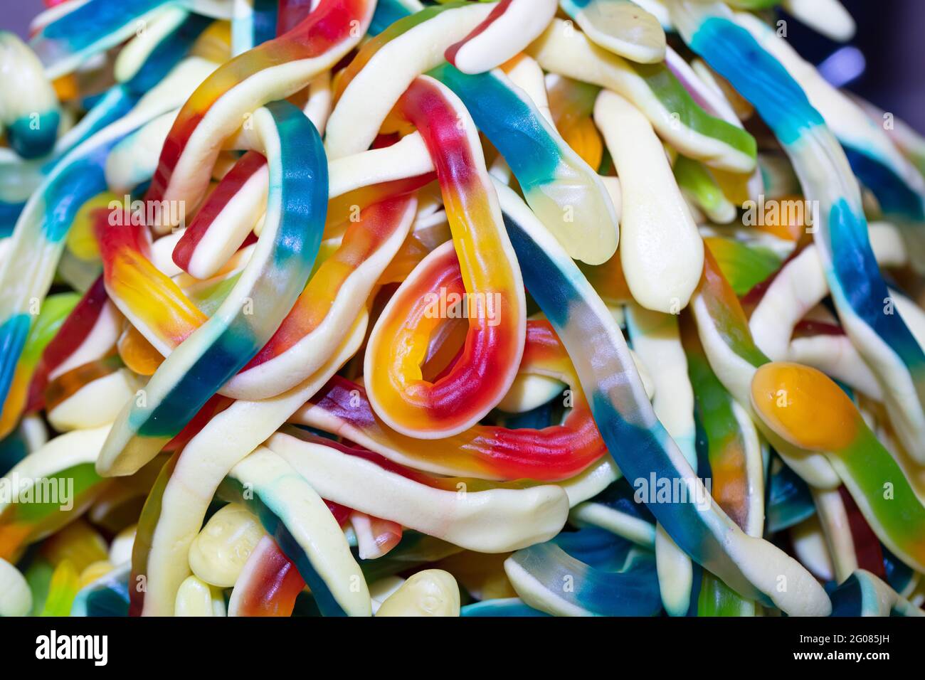 Multicolored jelly worm candies textured background Stock Photo - Alamy