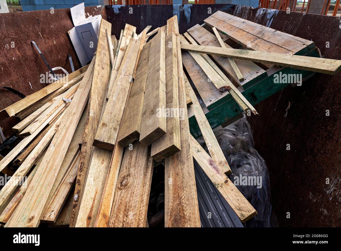 Planks of unwanted timber and pallets thrown into a dumpster at a house ...