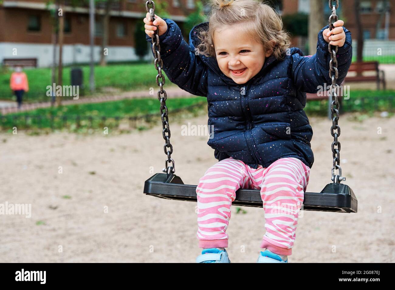 Toddler girl having fun on chain swing Stock Photo - Alamy