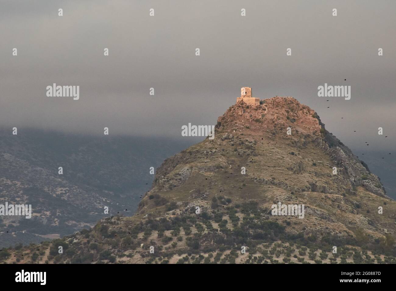 Olvera castle on the top of a rocky mountain on the foggy sky ...