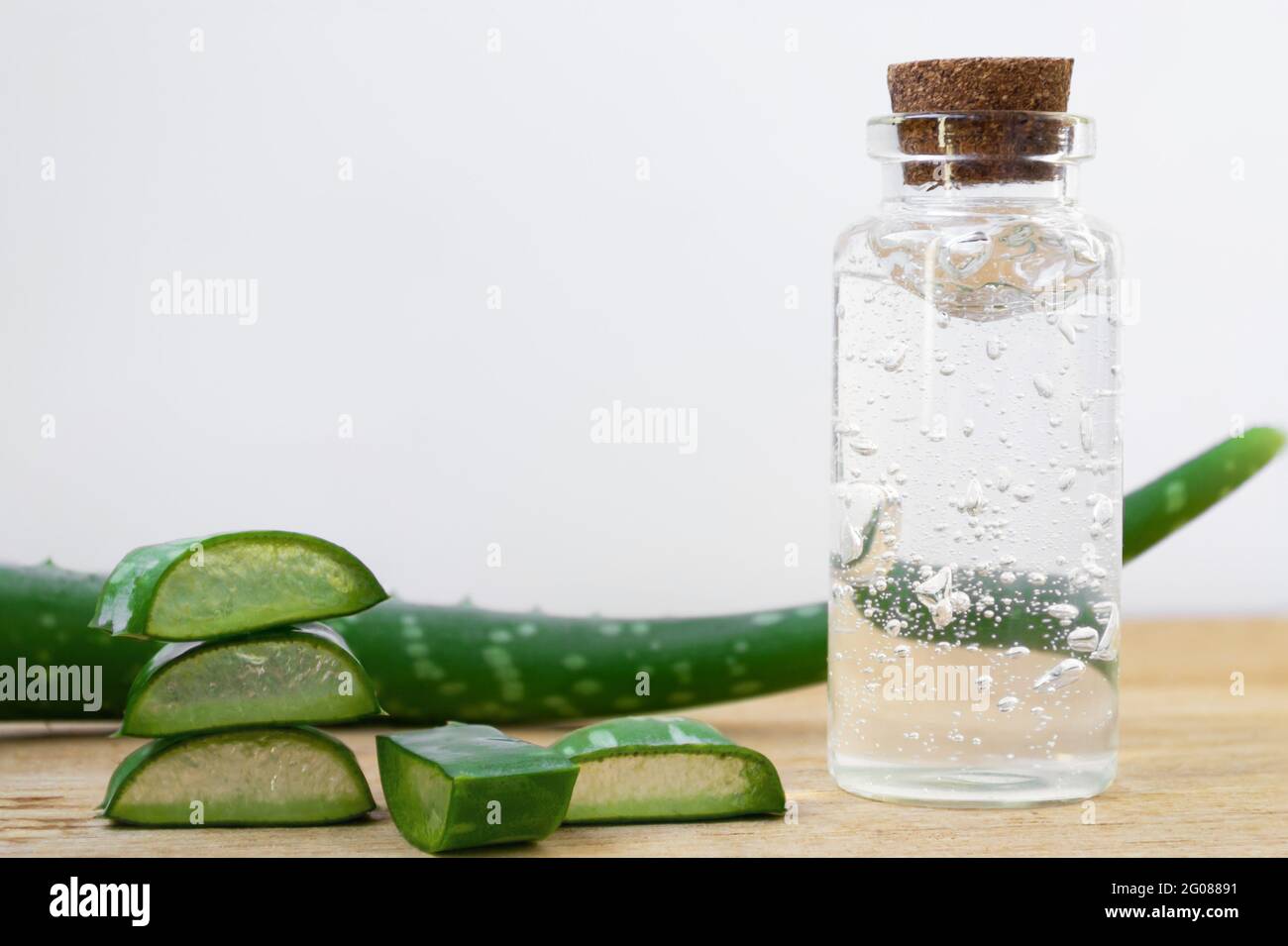 Glass bottle of aloe vera gel with whole leaves and plant pieces on ...