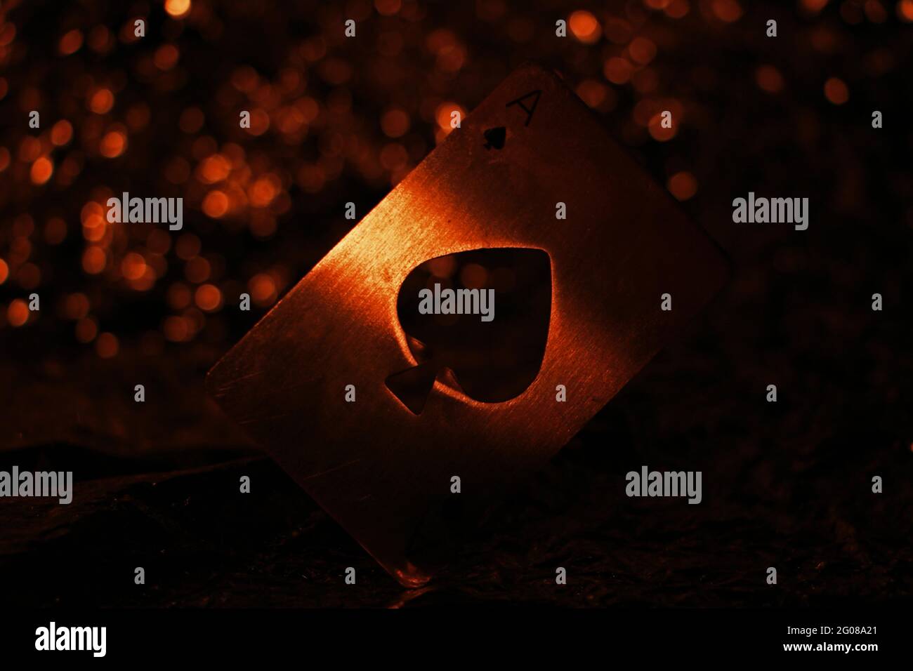 Closeup shot of an ace of spades metallic card isolated on the red ...