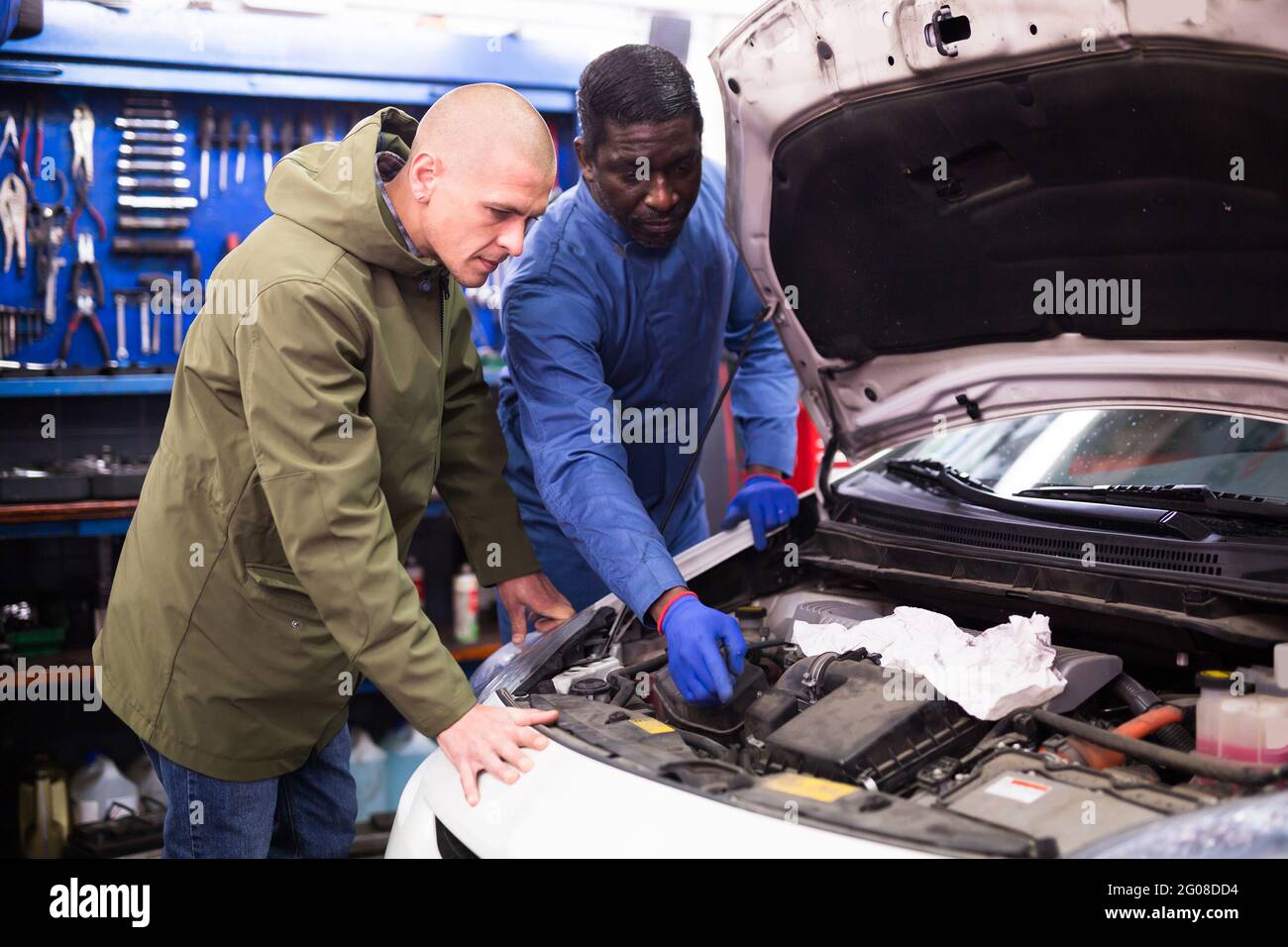 Owner of car explains the problem with car engine to mechanic of the ...