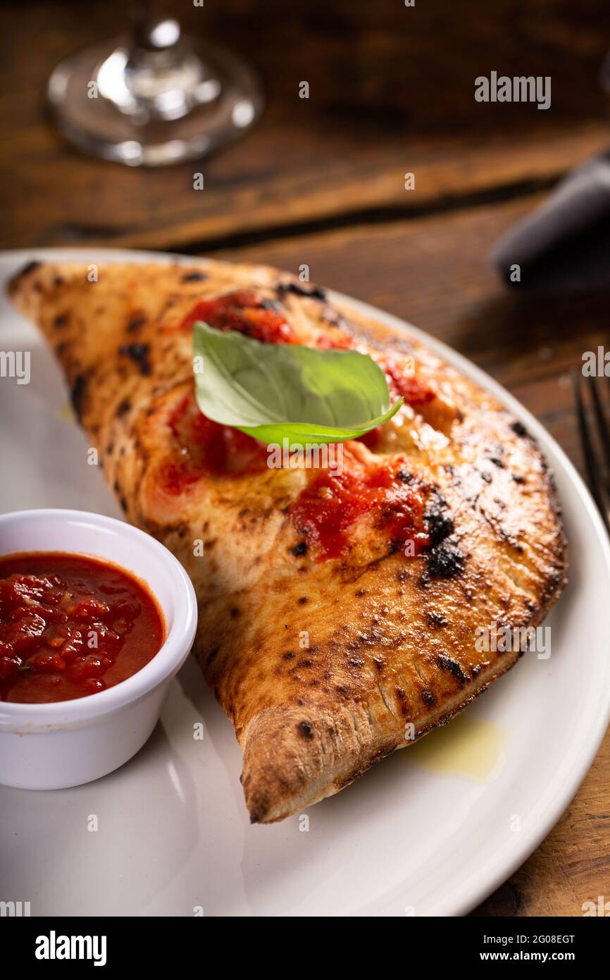 Traditional Italian cheese calzone with marinara sauce Stock Photo - Alamy
