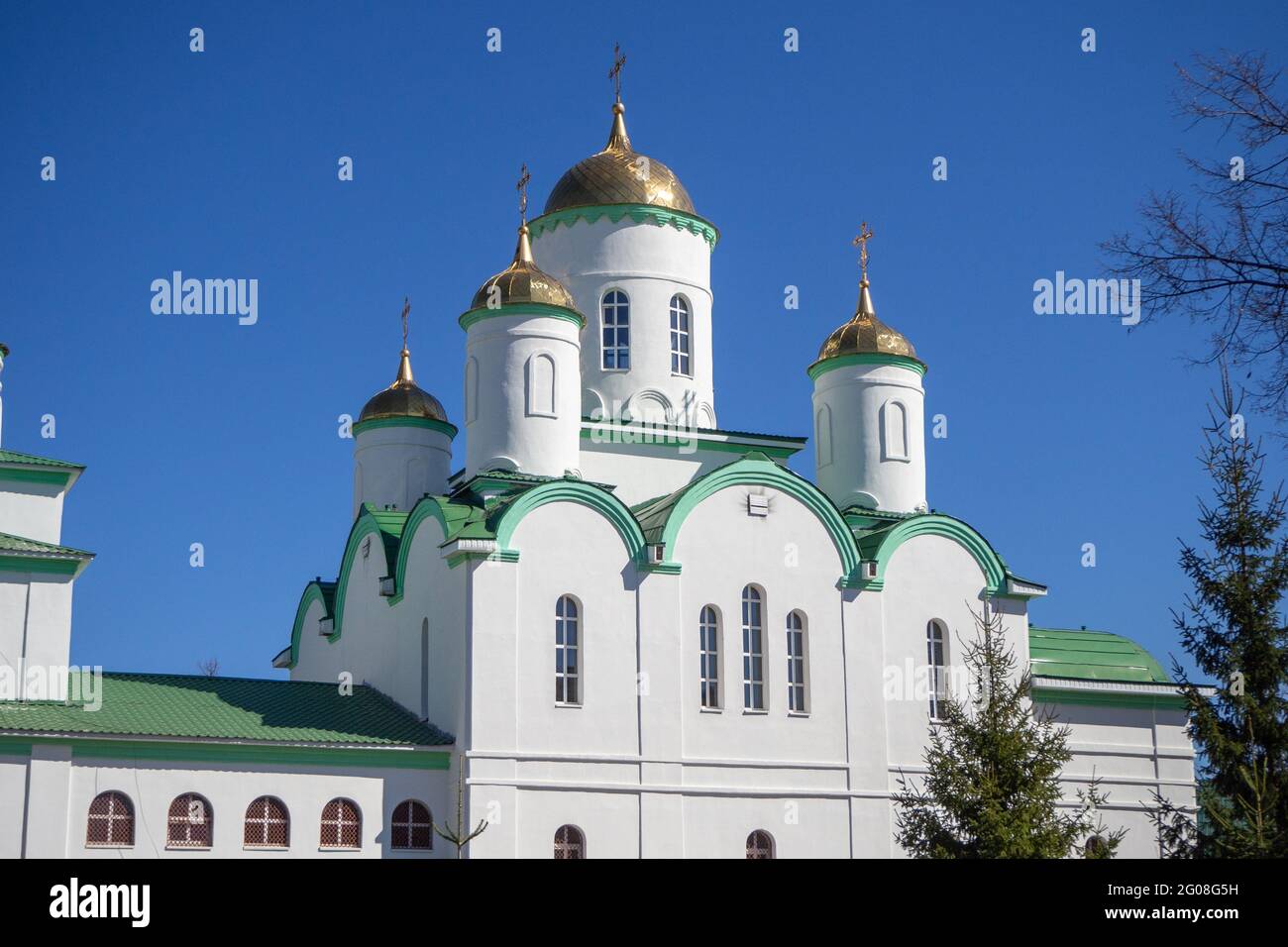 Orthodox church with white walls and golden domes against the blue sky ...