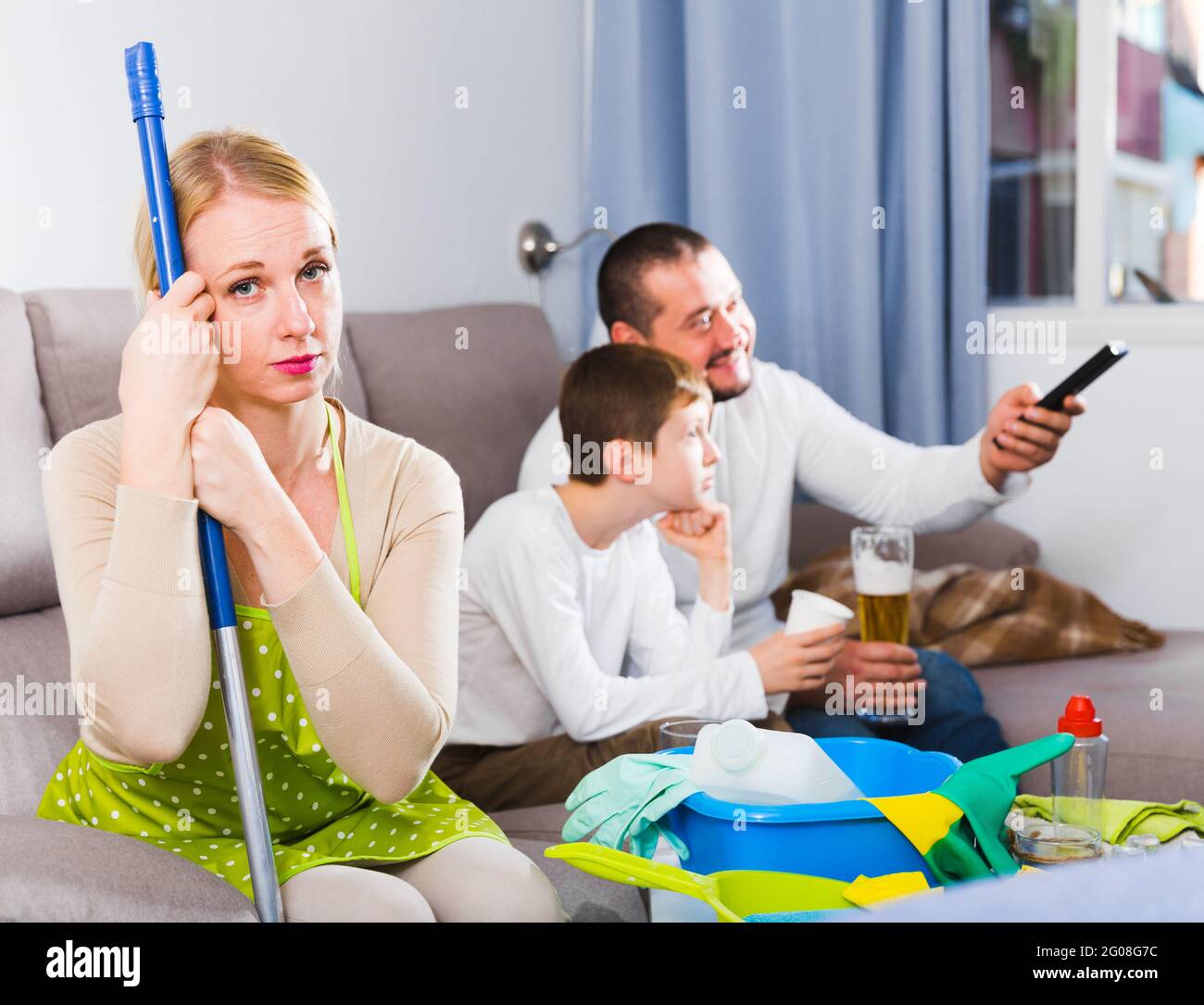 Upset woman with cleaning equipment Stock Photo - Alamy
