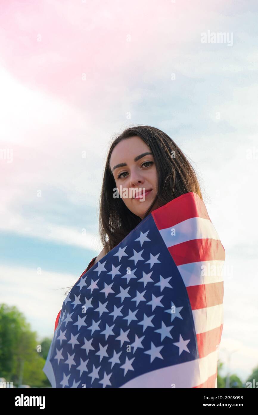 Young millennial brunette woman holding The National Flag of USA ...