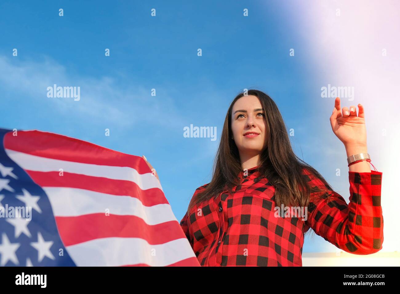 Young millennial brunette woman holding The National Flag of USA ...