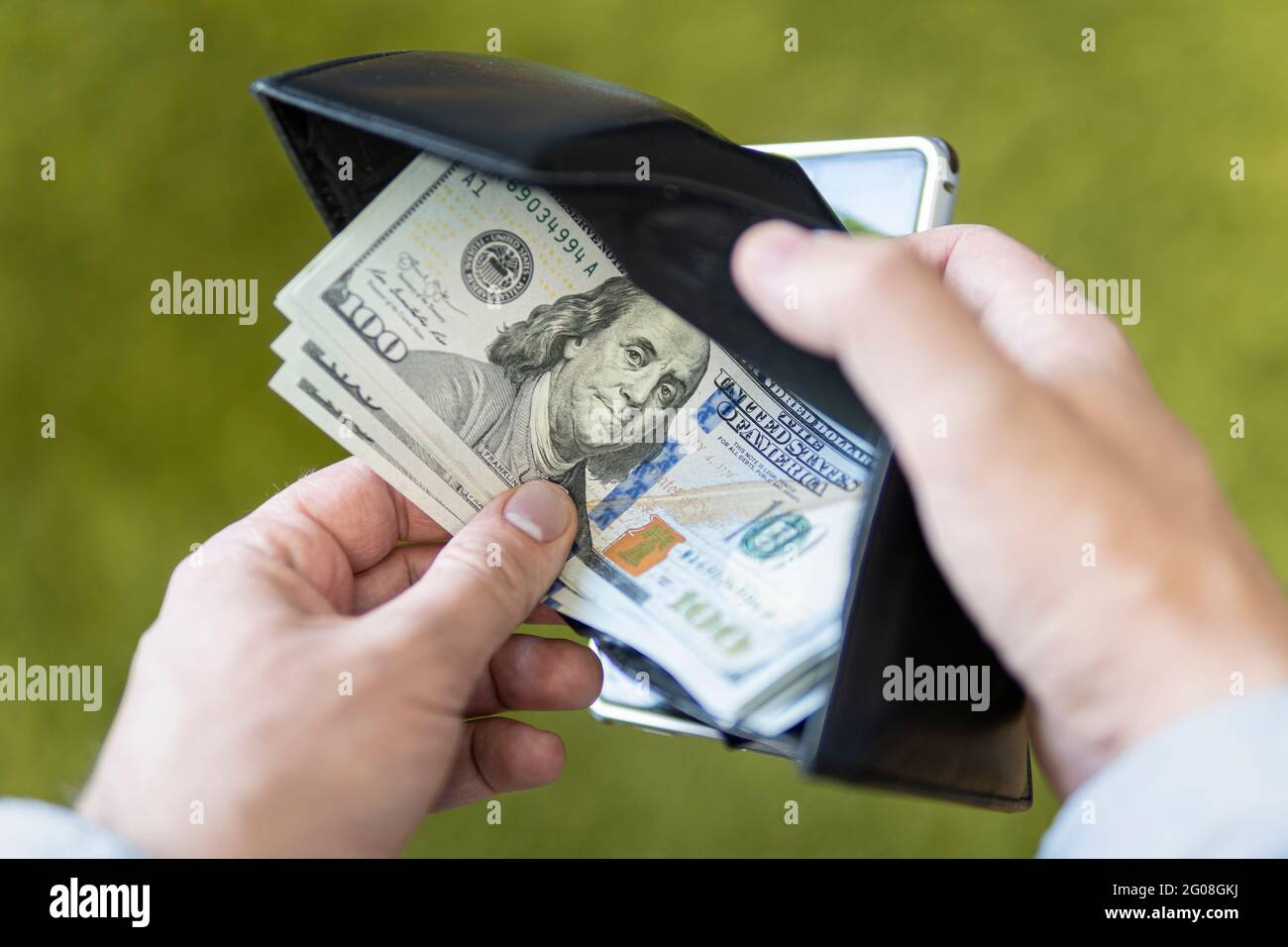 Purse with dollars in their hands. A male businessman opens a black ...