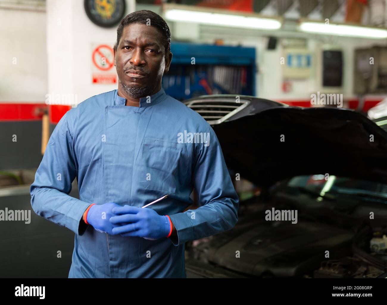 Portrait of african male mechanician posing in workshop Stock Photo - Alamy