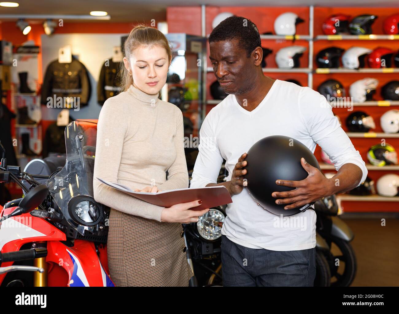 Polite smiling female seller communicating with male customer in modern ...